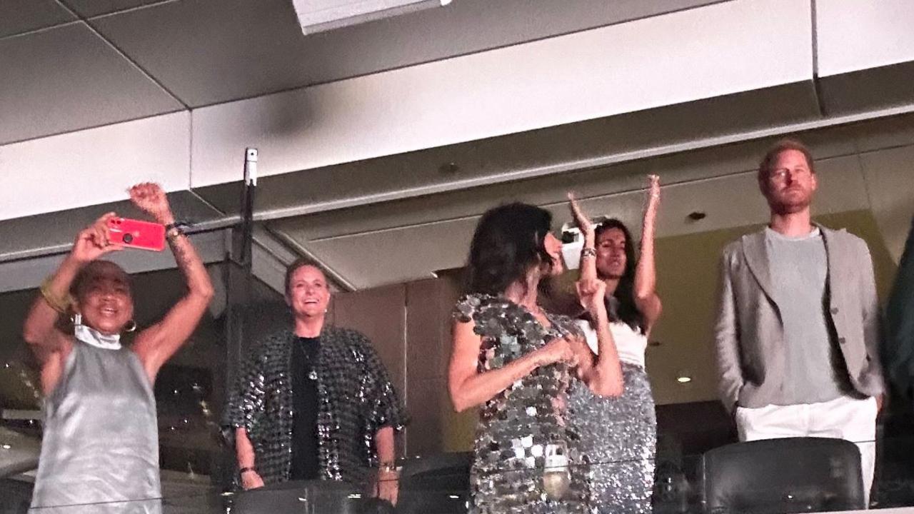 Принцот Хари со раце во џебови на концертот на Бијонсе, до него се ...